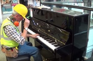 Construction worker plays boogie-woogie piano jam in airport
