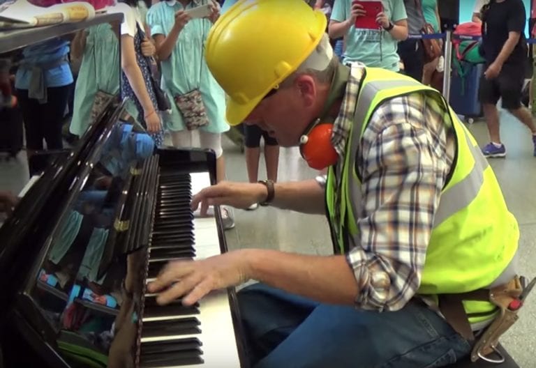 Construction worker plays boogie-woogie piano jam in airport