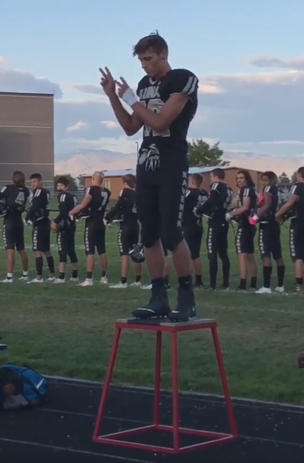 Crowd goes wild for high school football player who signs National Anthem