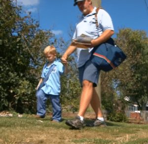 Mailman gets help on job from 4-year-old pint-sized boy in matching outfit