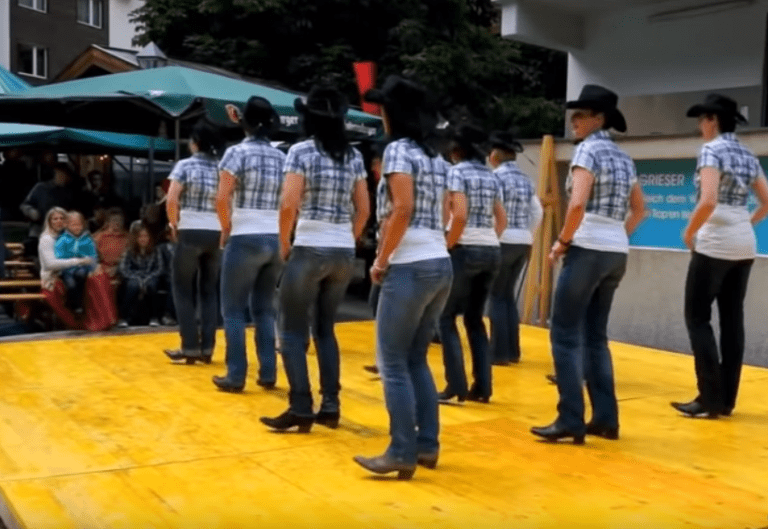 Crowd Gathers For Women’s Carefully Timed Line Dance