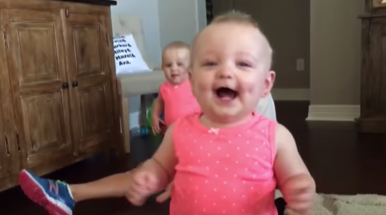 Baby takes first steps then leans back for a hearty laugh