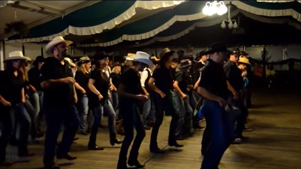 Cowboys and cowgirls shake up dance floor with perfect country line dance