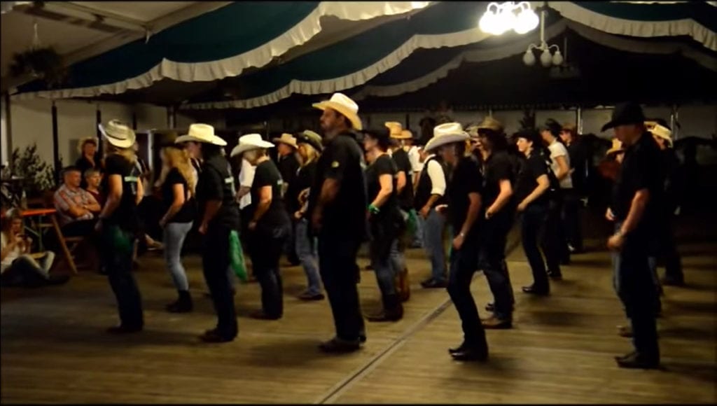Cowboys and cowgirls shake up dance floor with perfect country line dance