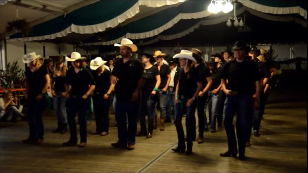 Cowboys and cowgirls shake up dance floor with perfect country line dance
