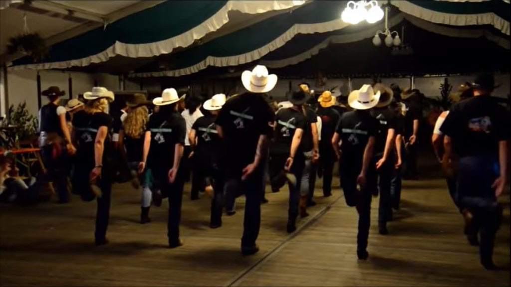 Cowboys and cowgirls shake up dance floor with perfect country line dance