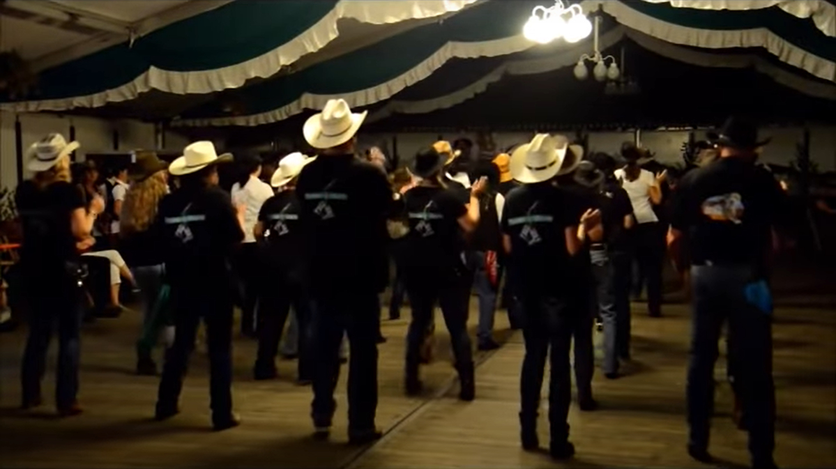 Cowboys and cowgirls shake up dance floor with perfect country line dance