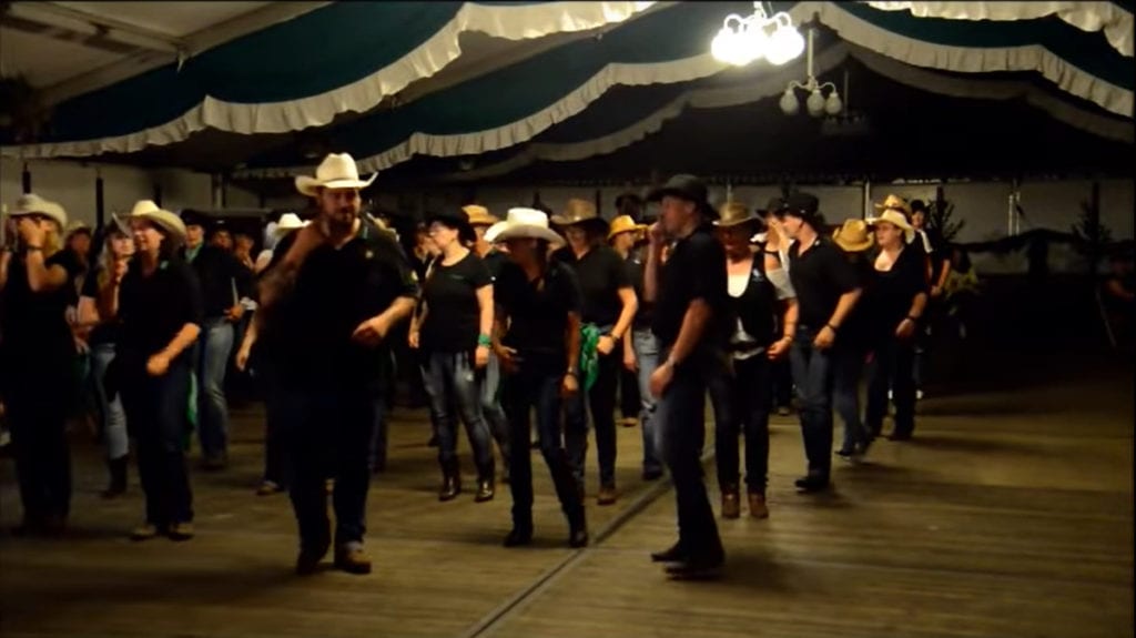 Cowboys and cowgirls shake up dance floor with perfect country line dance