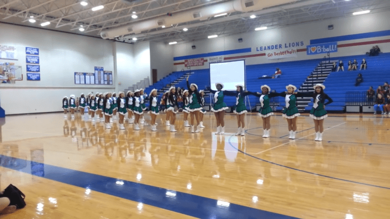 Cheerleaders take over gym floor with epic high-kick routine