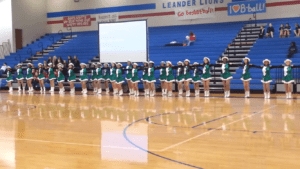 Cheerleaders take over gym floor with epic high-kick routine