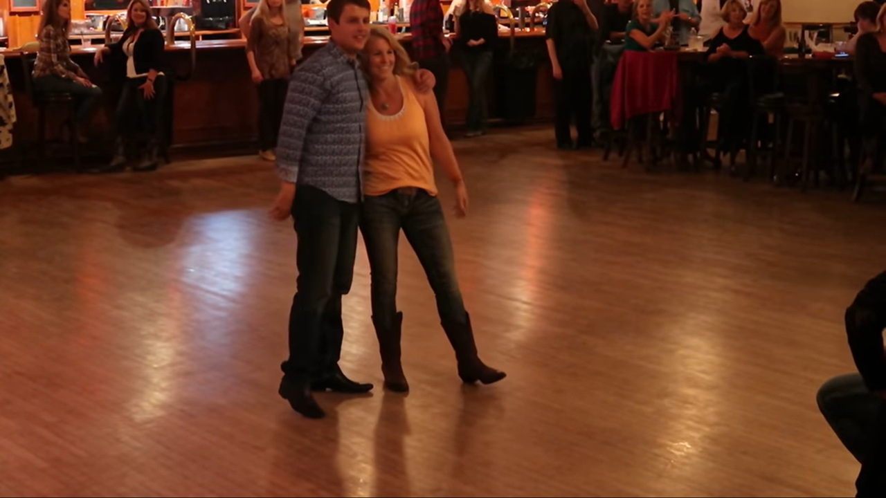 Couple cozies up on dance floor for smooth first country dance