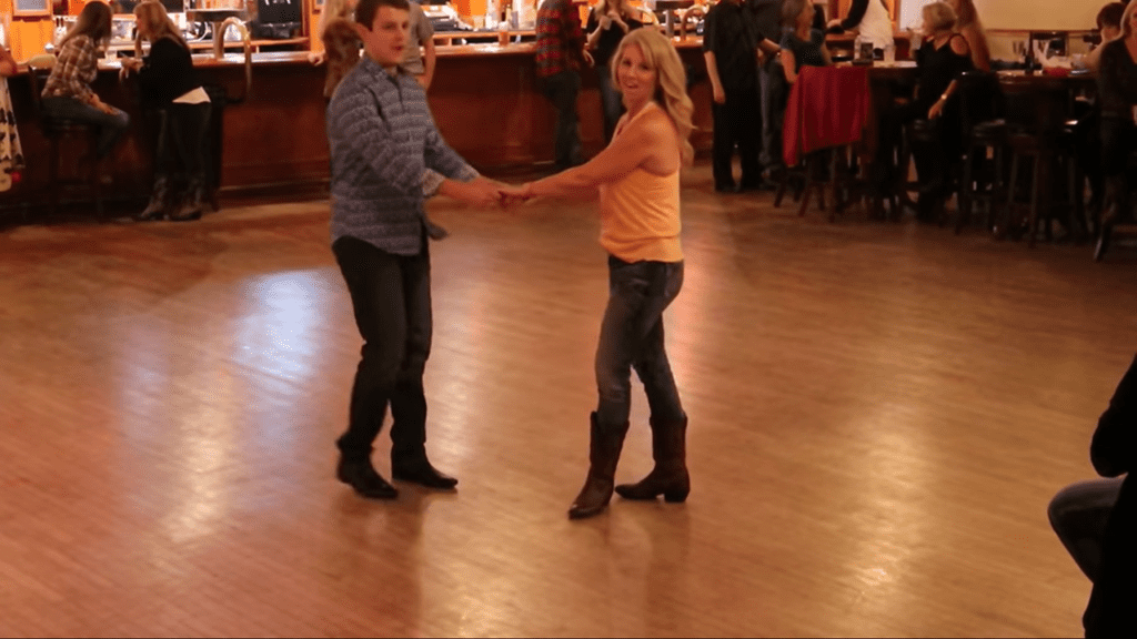 Couple cozies up on dance floor for smooth first country dance