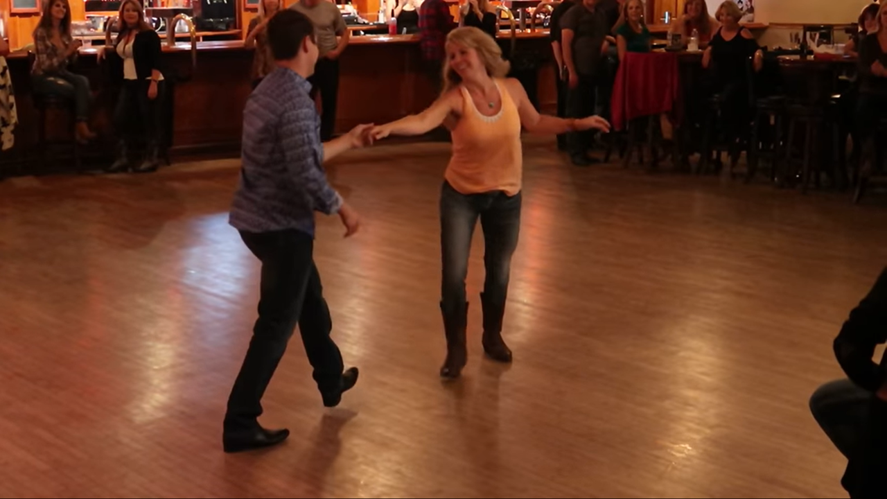 Couple cozies up on dance floor for smooth first country dance