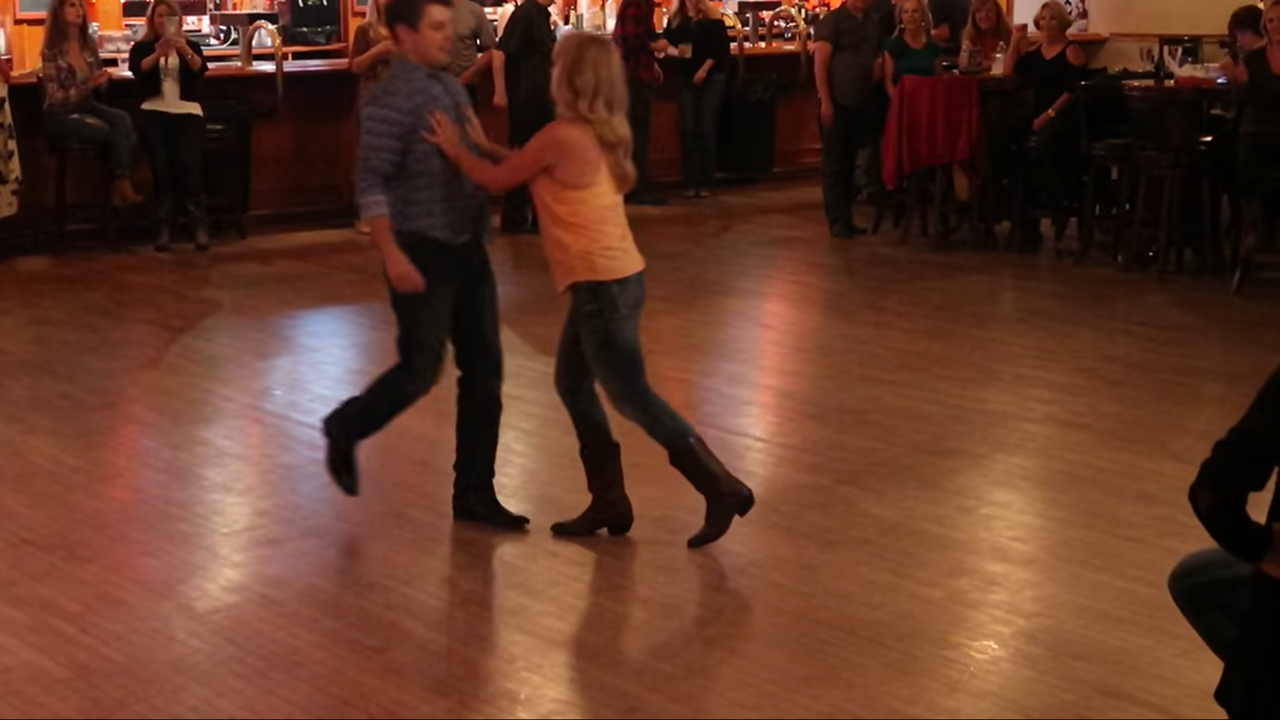 Couple cozies up on dance floor for smooth first country dance