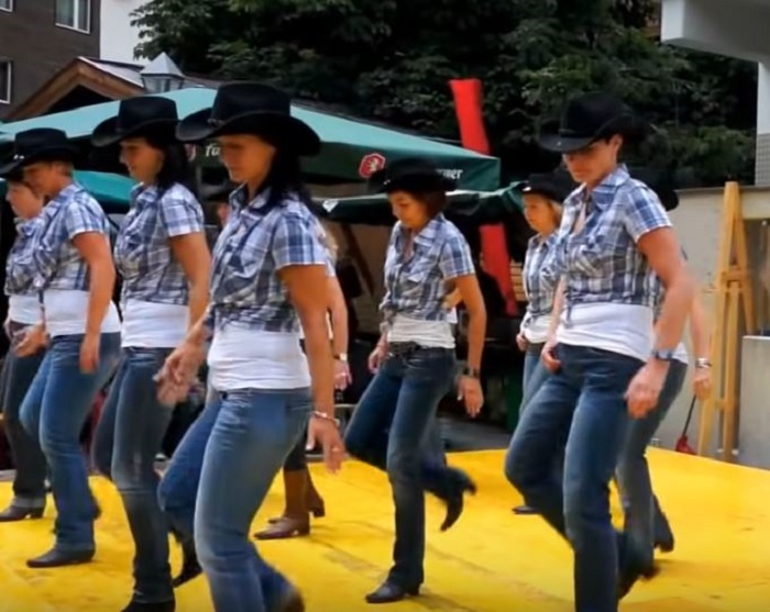 Dancers do lively line dance to classic country song