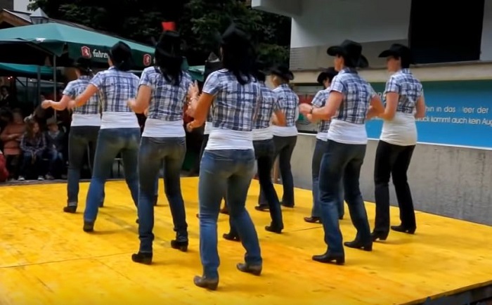 Dancers do lively line dance to classic country song