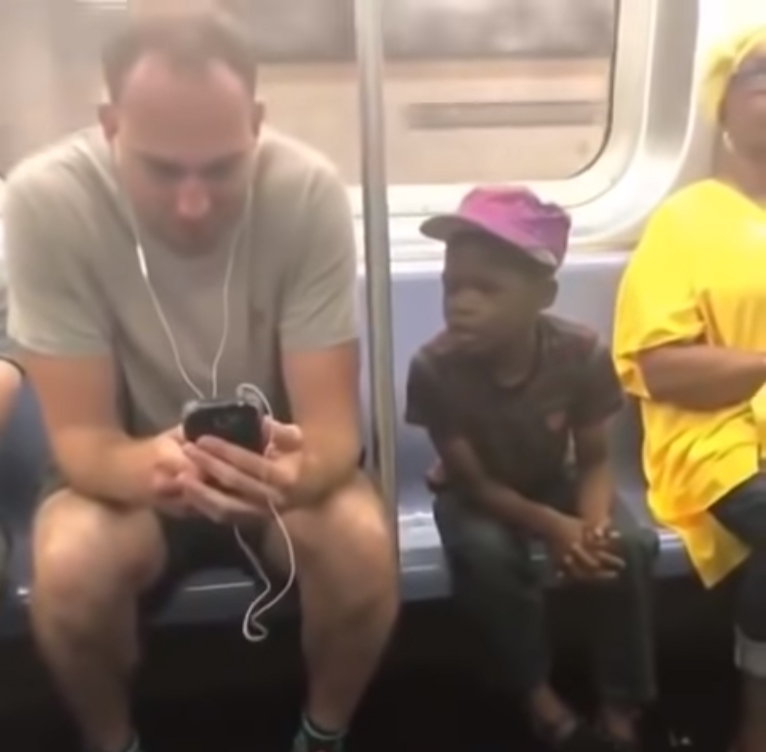 Child keeps looking at man’s phone unaware his next move is being recorded