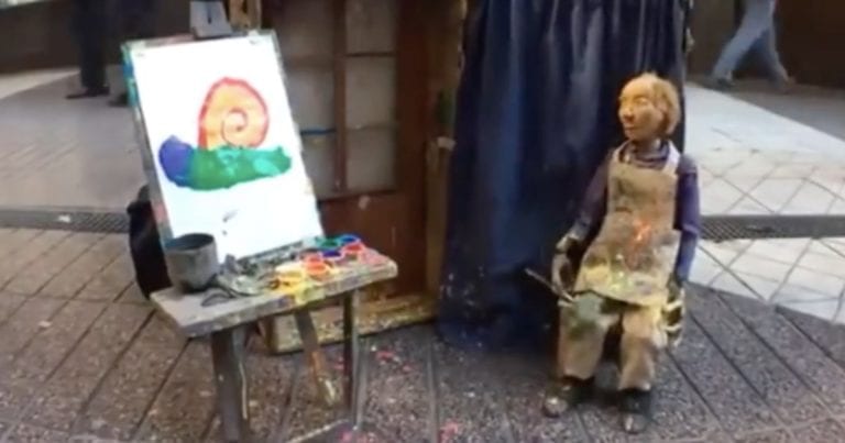 Puppet painter steps in front of blank canvas then delivers a work of art