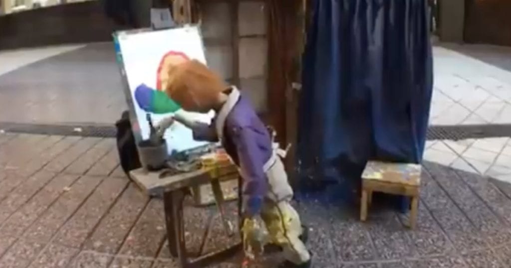 Puppet painter steps in front of blank canvas then delivers a work of art